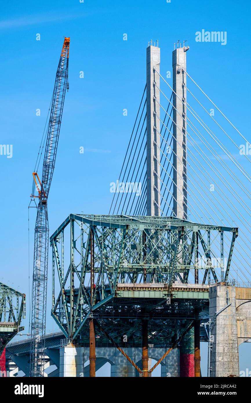 An old bridge is under demolition next to a new cable-stayed bridge ...