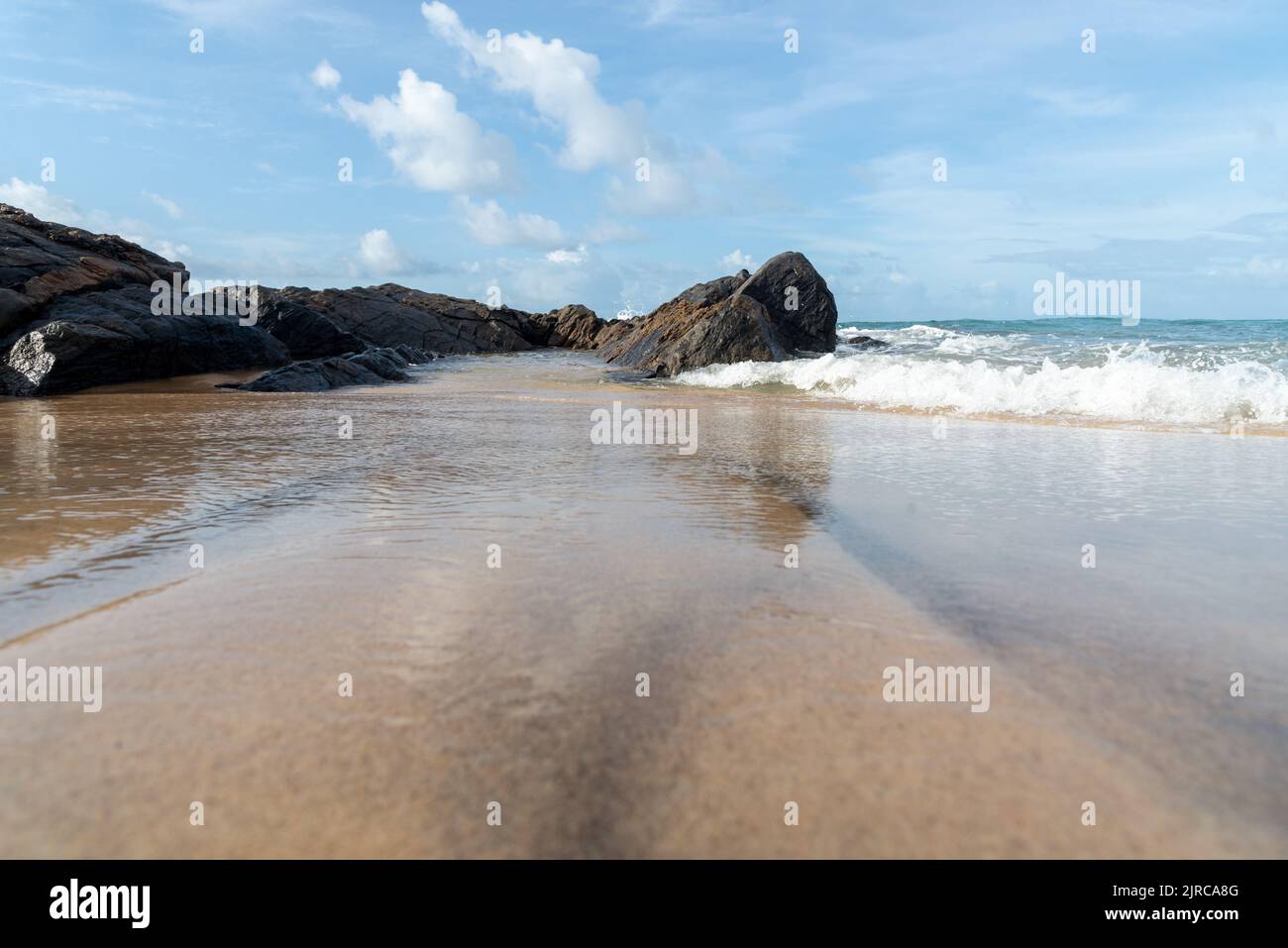 A wave breaks about a rock during a curtain on the sea. Farol da Barra ...