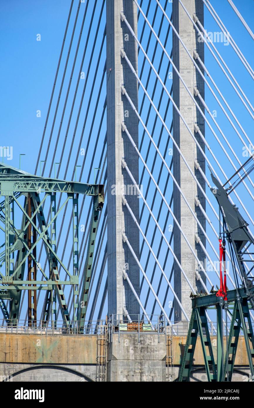 An old bridge is under demolition next to a new cable-stayed bridge ...