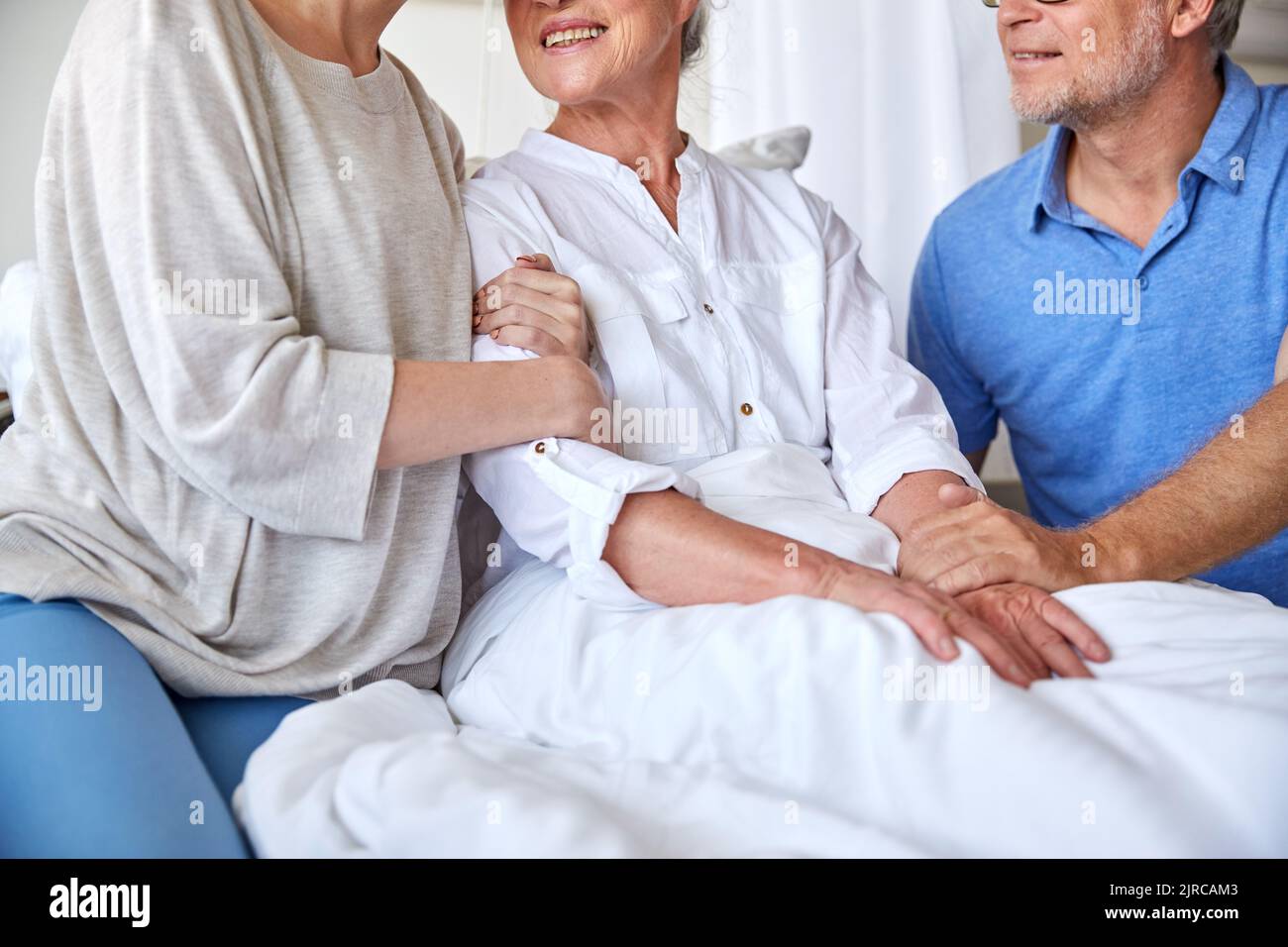 happy family visiting senior woman at hospital Stock Photo - Alamy