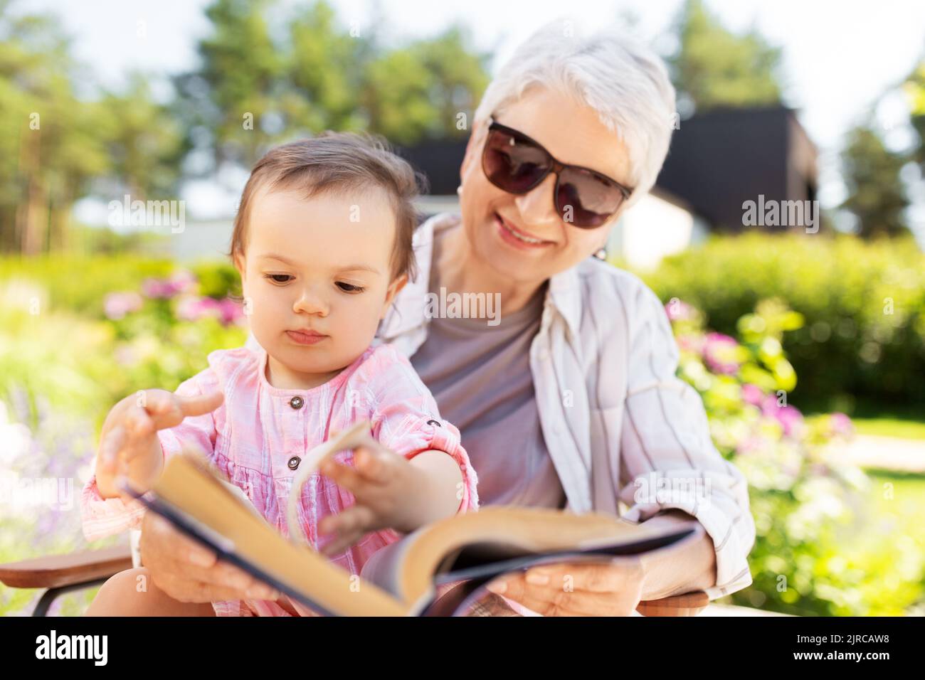 grandmother and baby granddaughter reading book Stock Photo - Alamy