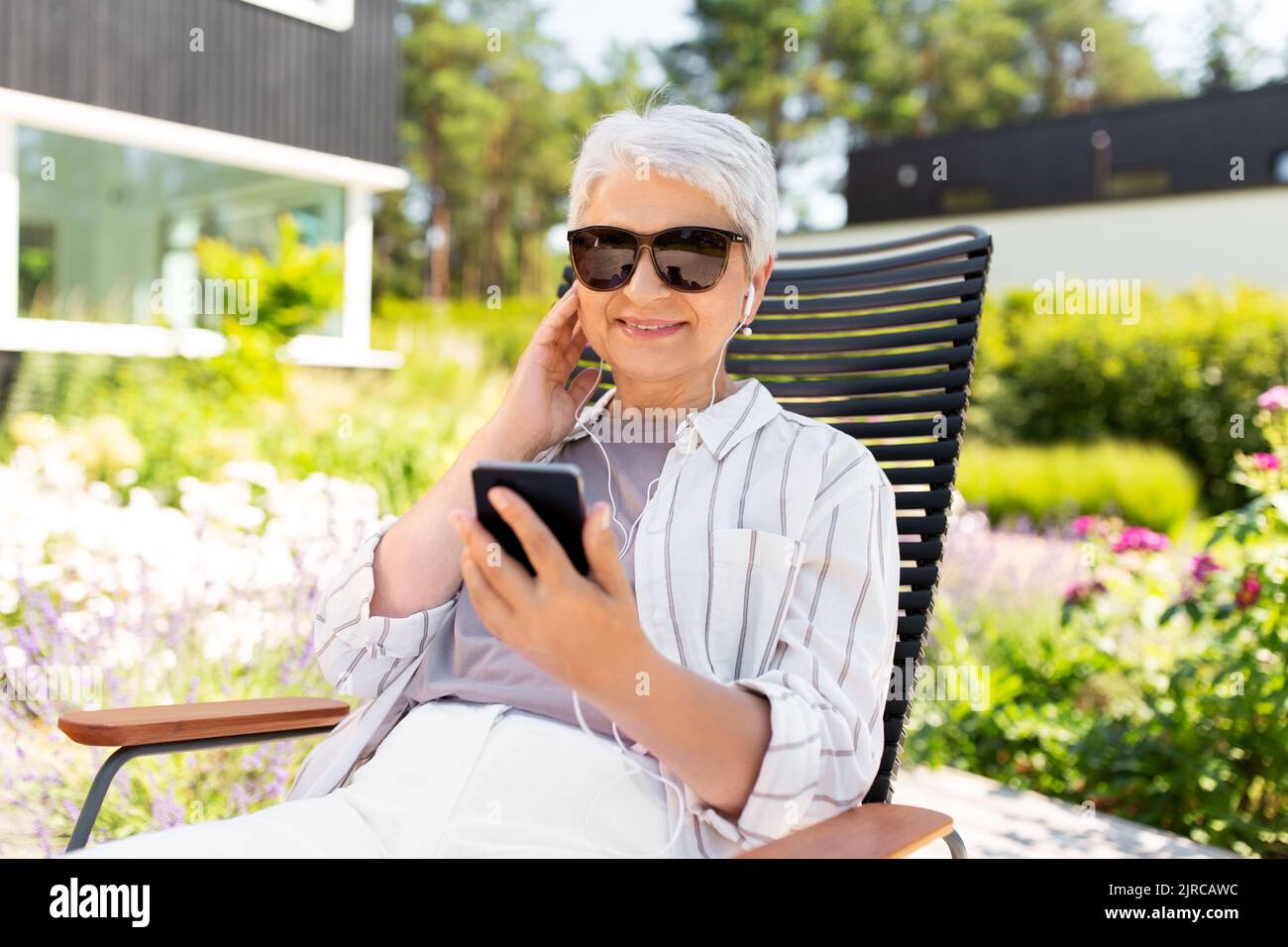 old woman with earphones and smartphone at garden Stock Photo - Alamy
