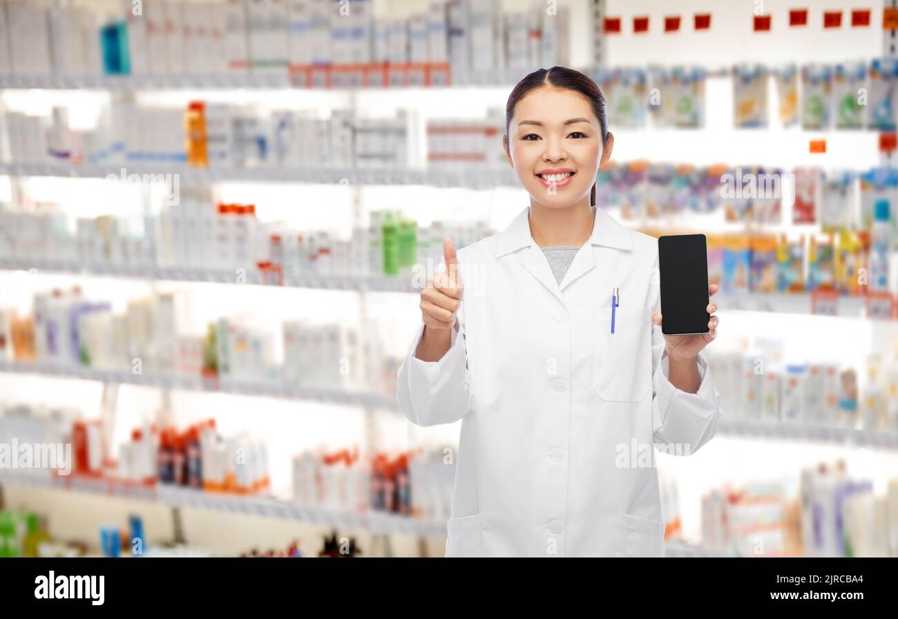 asian pharmacist with phone shows thumbs up Stock Photo - Alamy