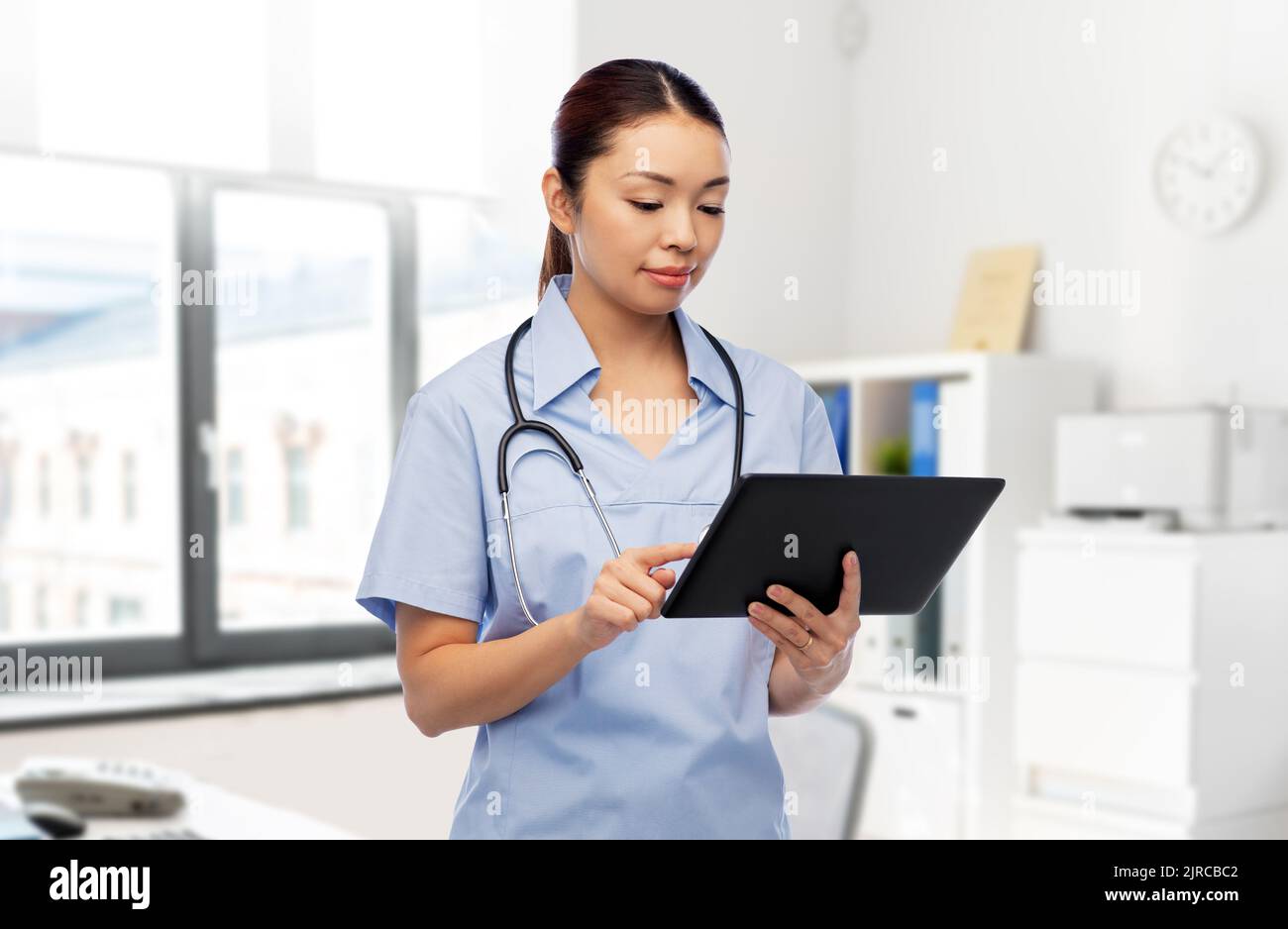 asian female nurse with tablet pc at hospital Stock Photo - Alamy