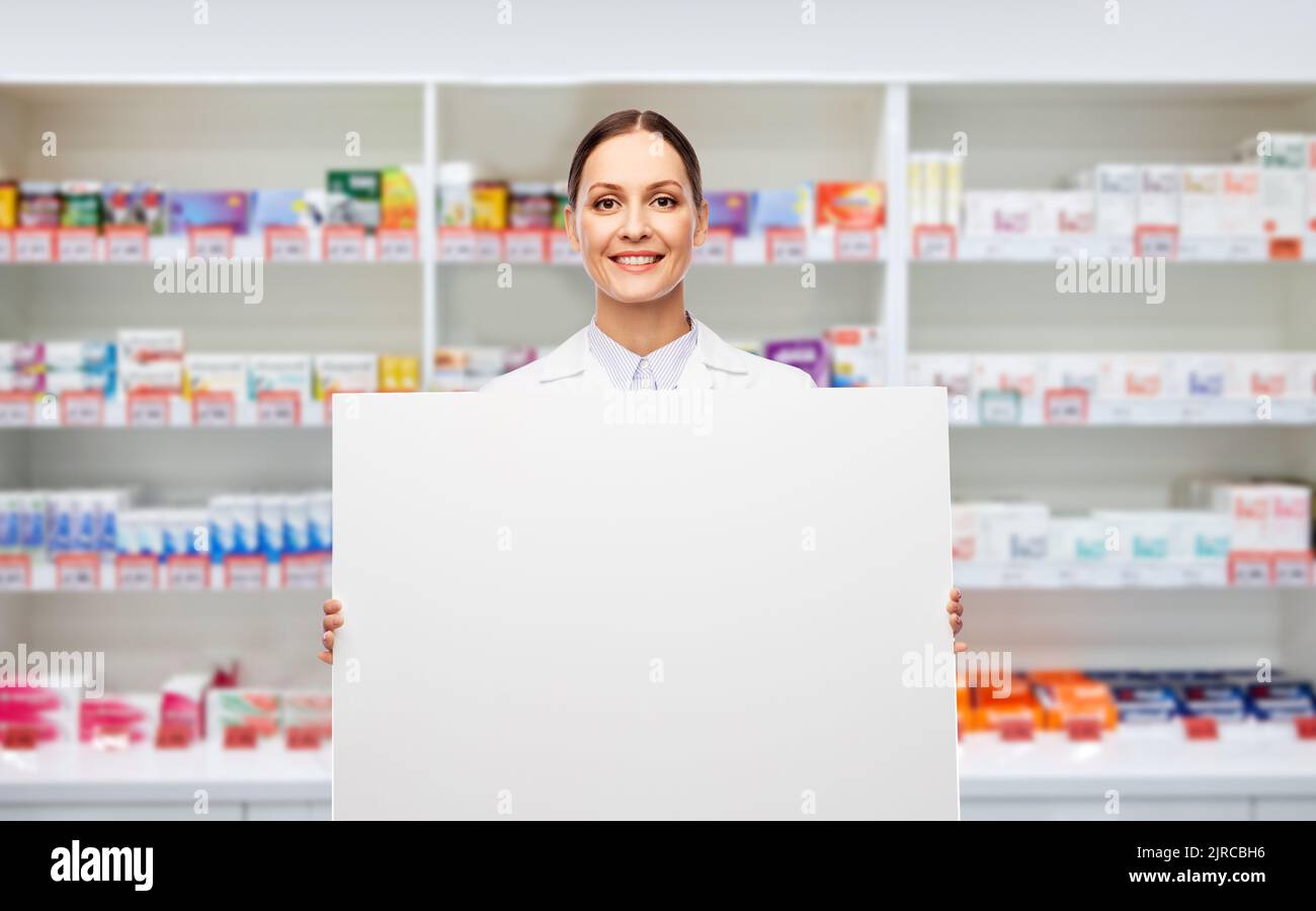 happy smiling female pharmacist with white board Stock Photo - Alamy
