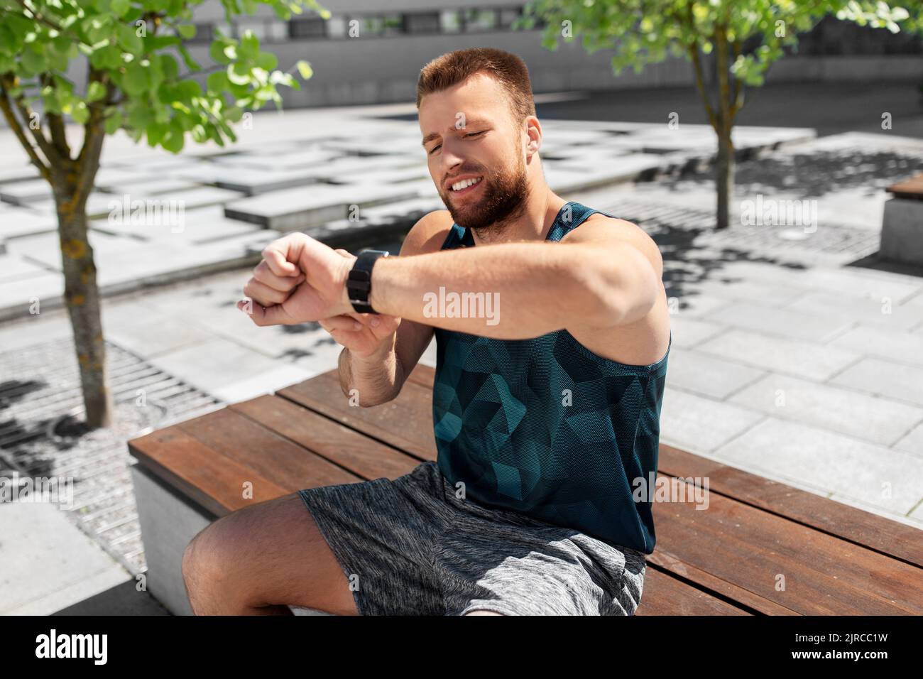 man with smart watch sitting on bench Stock Photo - Alamy