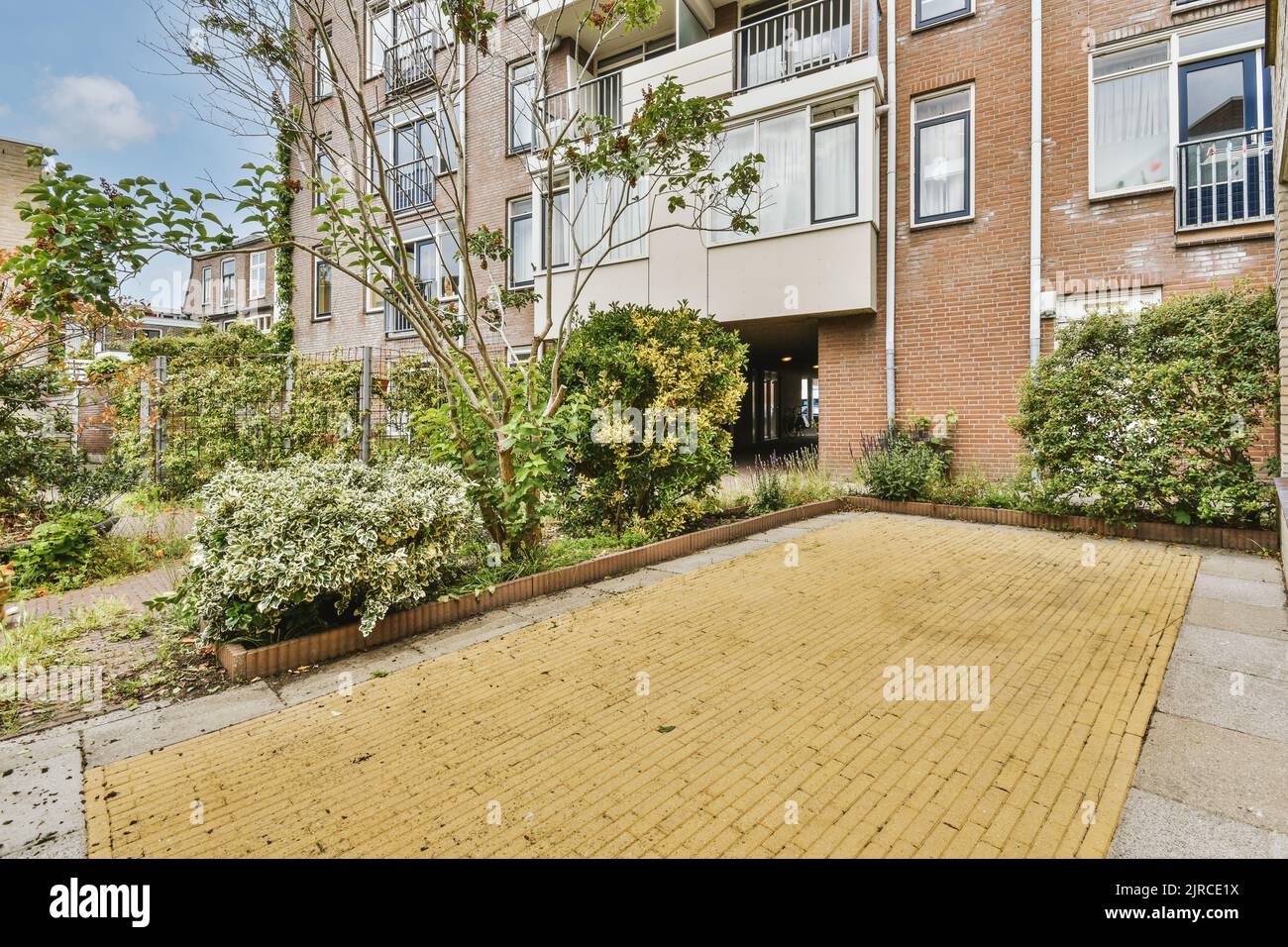 The front view of a brick building with signs,pavement and wooden doors ...