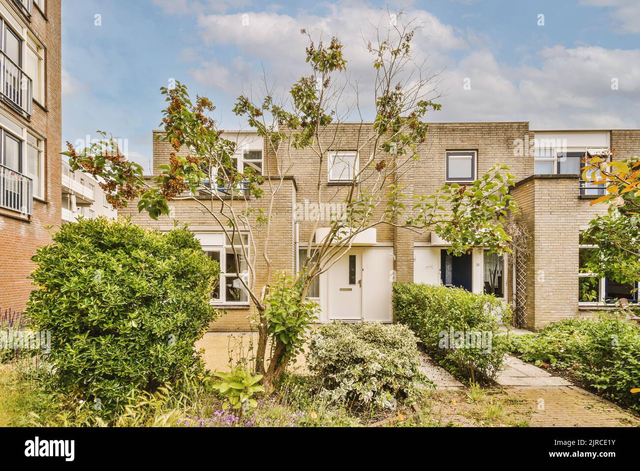 The front view of a brick building with signs,pavement and wooden doors ...