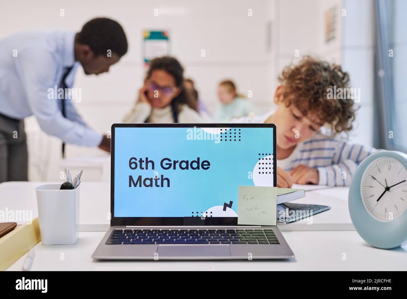Background image of open laptop in school classroom with 6th Grade math ...