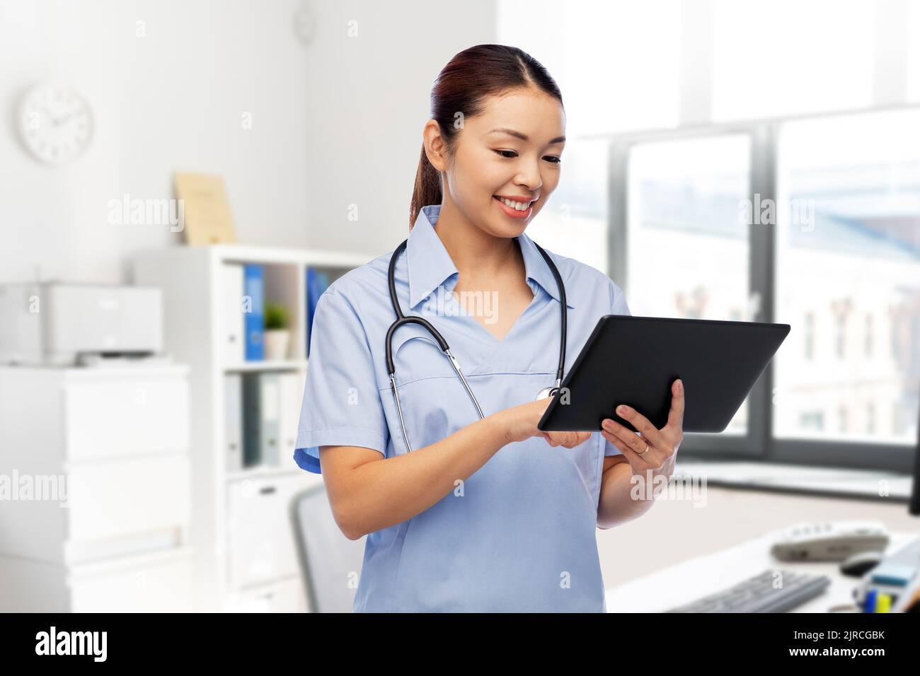 asian female nurse with tablet pc at hospital Stock Photo - Alamy