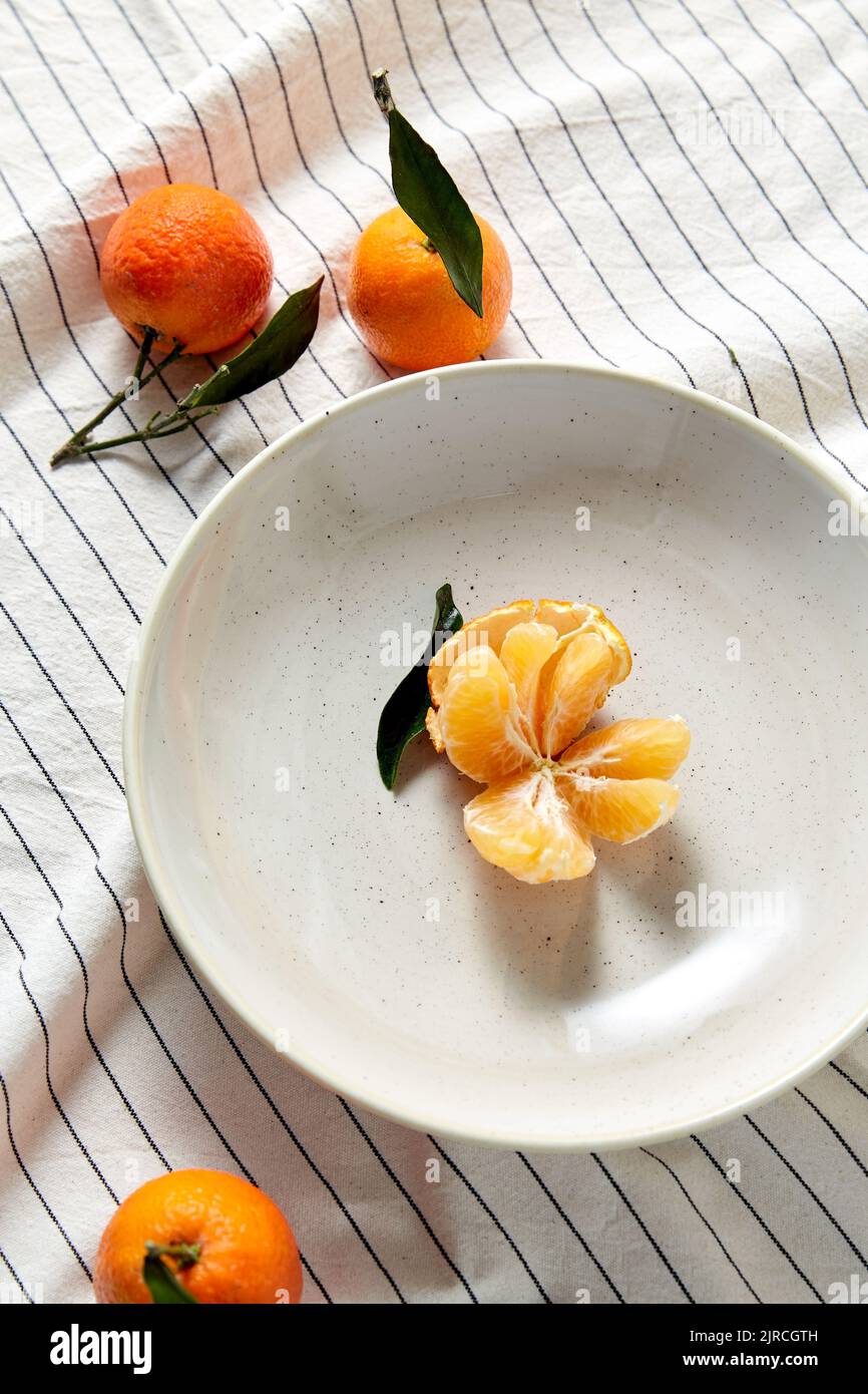 still life with mandarins on plate over drapery Stock Photo - Alamy