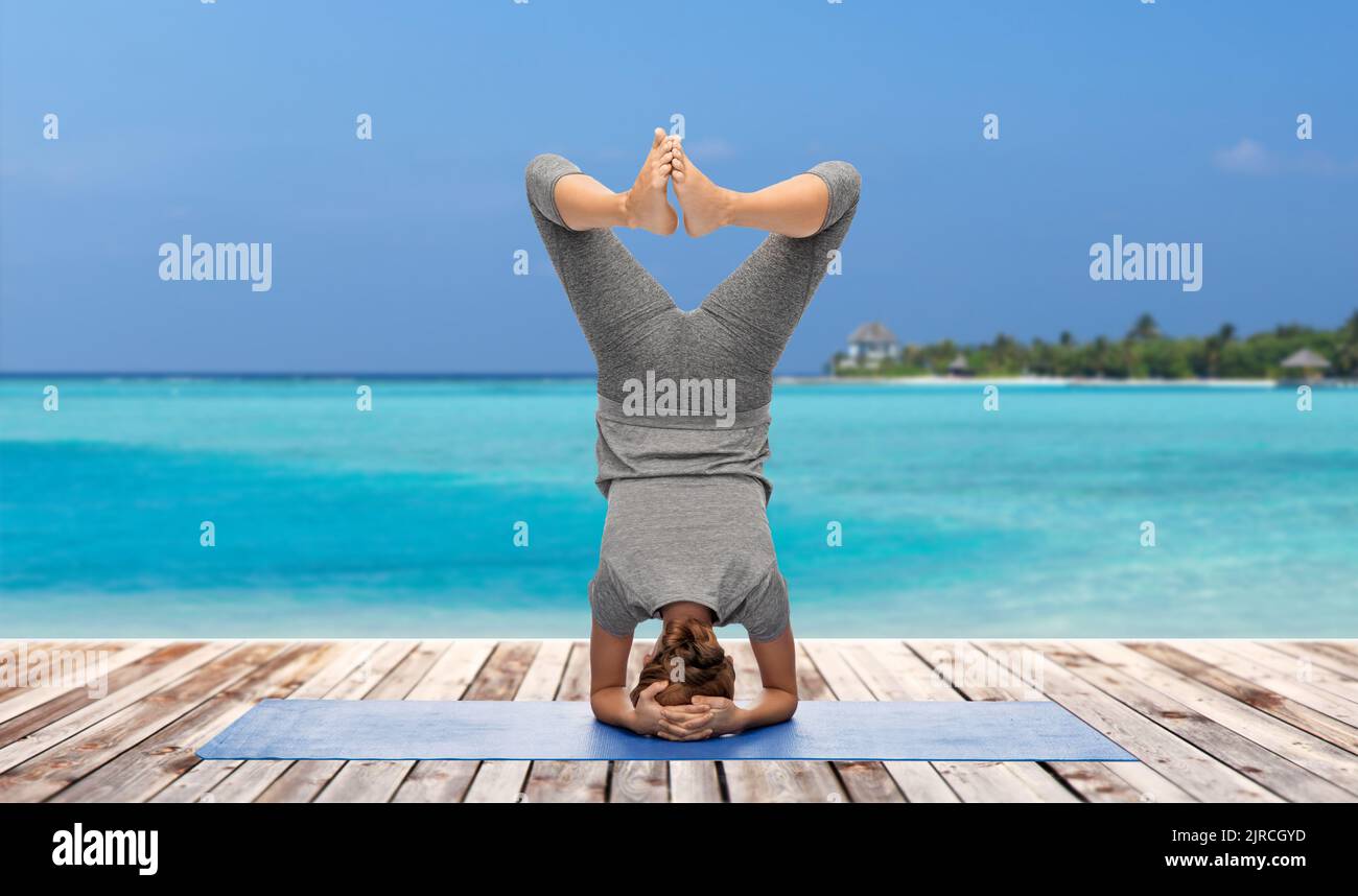 woman making yoga in headstand over ocean Stock Photo - Alamy