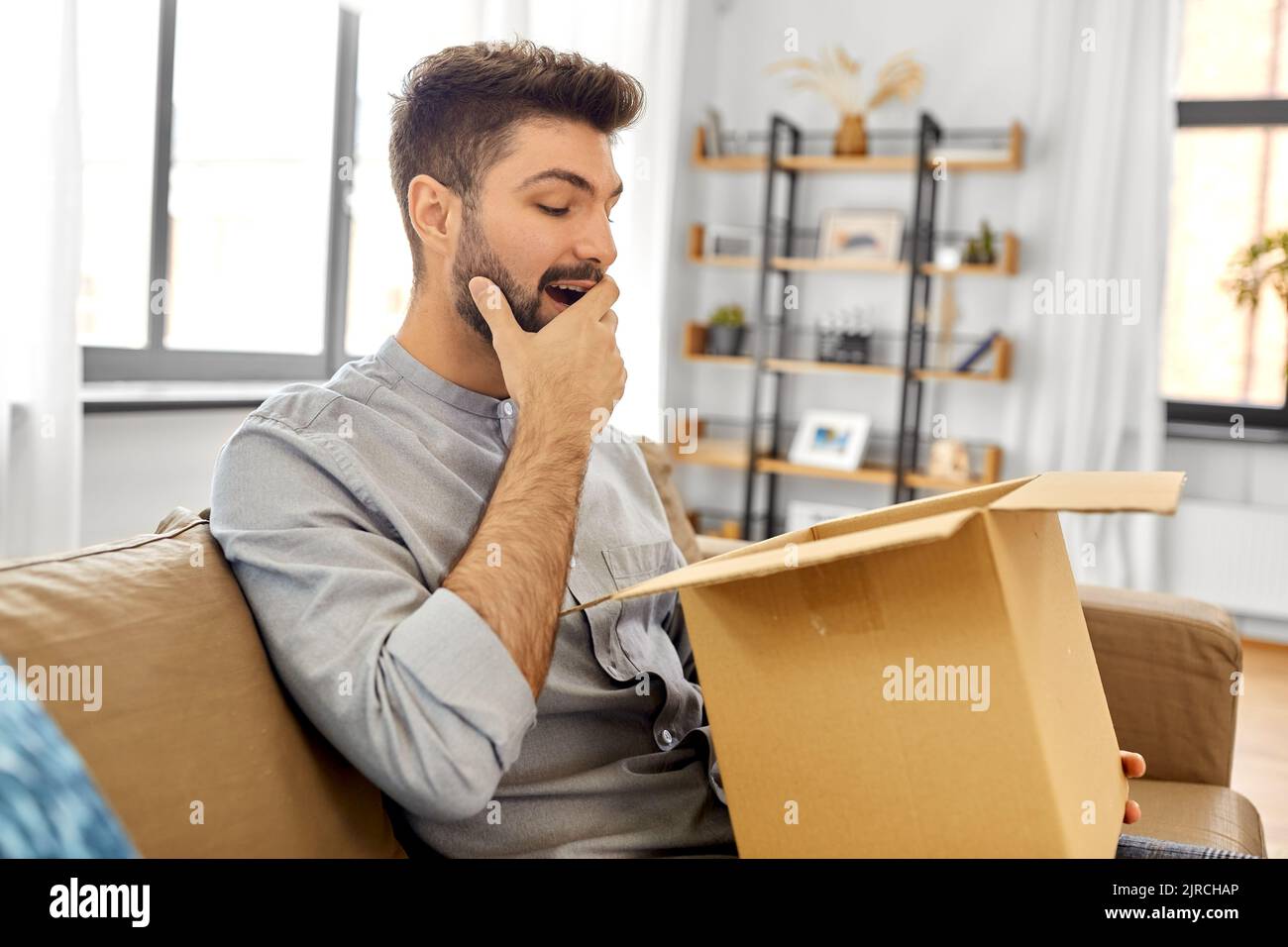happy smiling man with open parcel box at home Stock Photo - Alamy