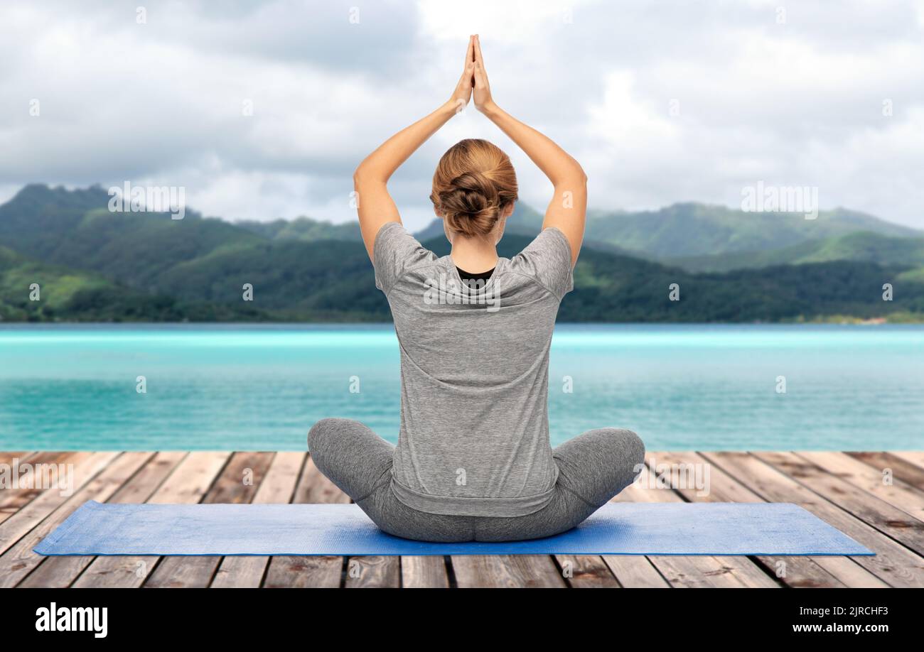 woman doing yoga in lotus pose over ocean Stock Photo - Alamy