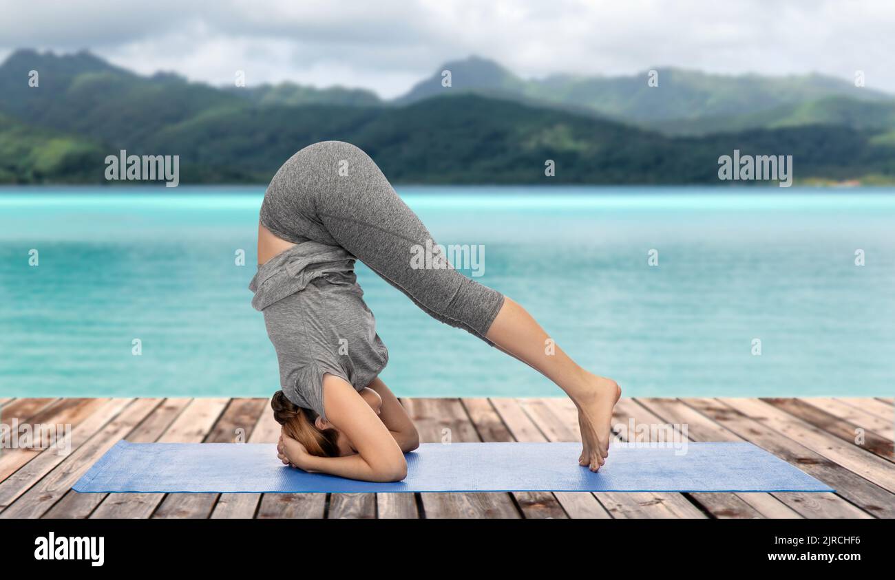 woman making yoga in headstand pose over ocean Stock Photo - Alamy
