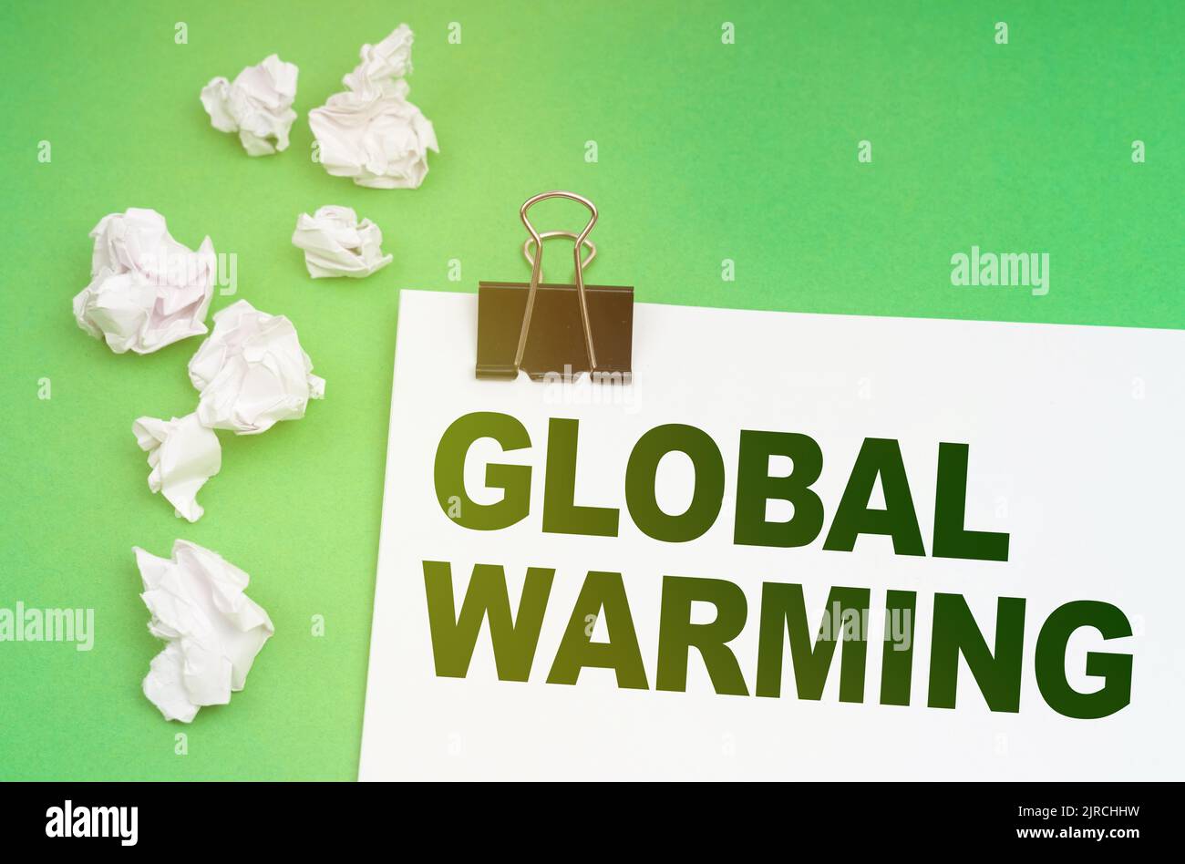 Ecology concept. On a green background, crumpled paper and a sheet with ...