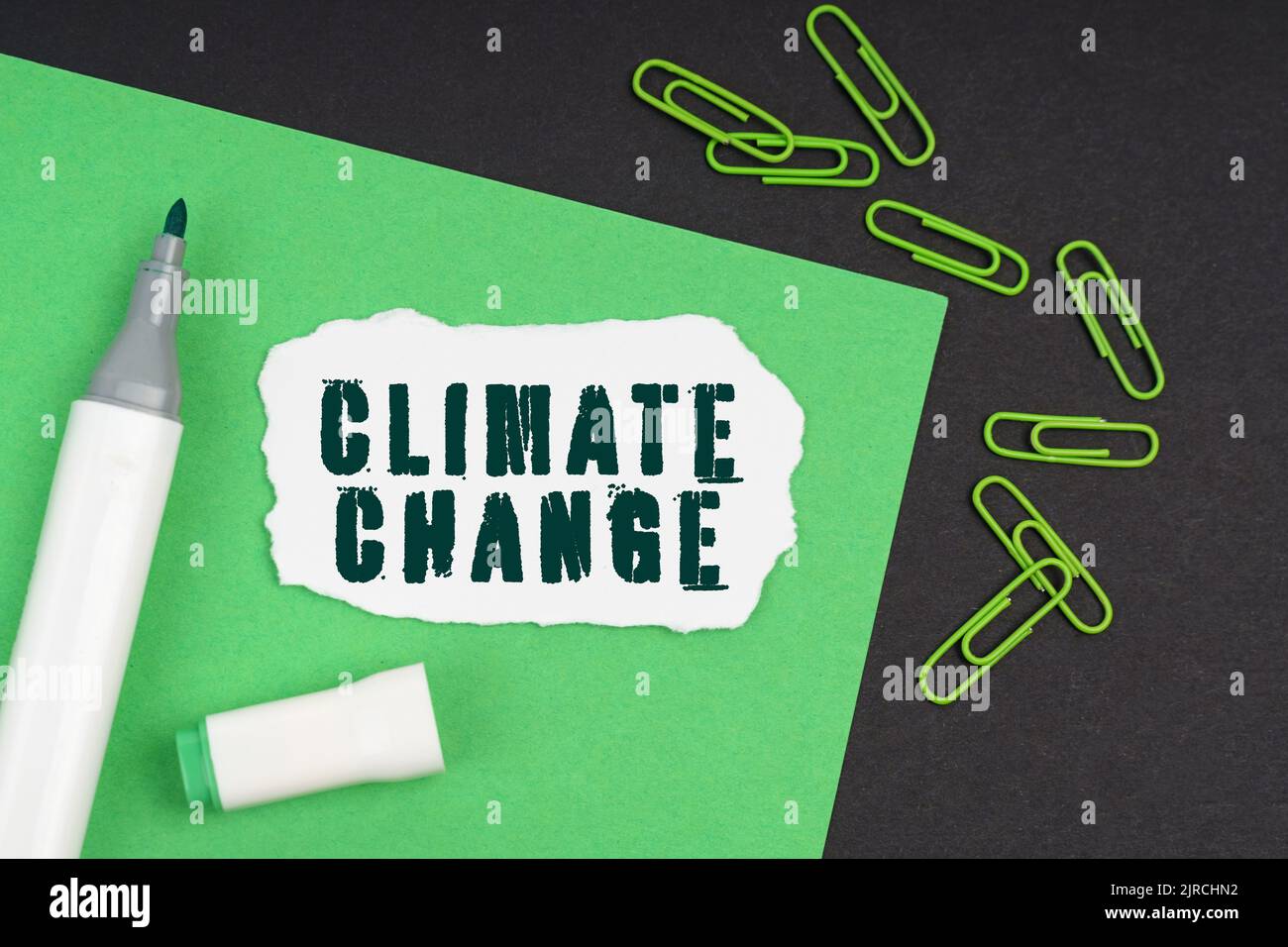 Ecology concept. On a black background, a marker, paper clips, a sheet ...