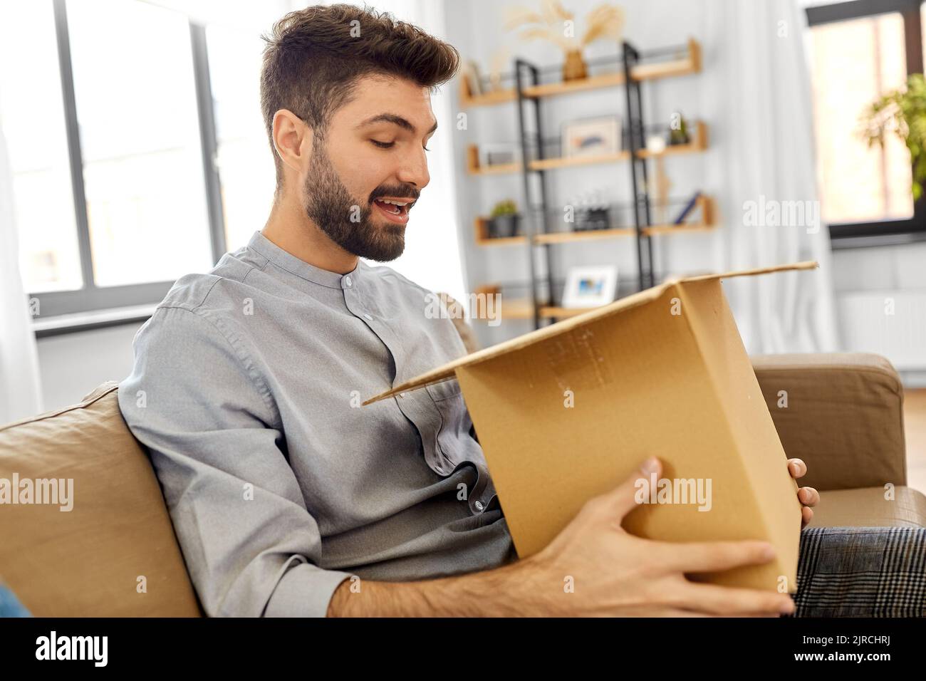 happy smiling man with open parcel box at home Stock Photo - Alamy