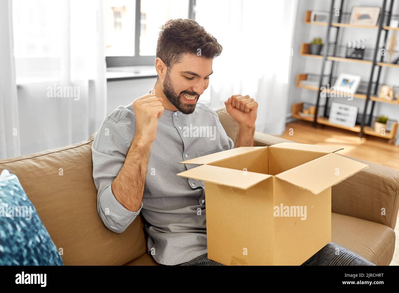 happy smiling man with open parcel box at home Stock Photo - Alamy
