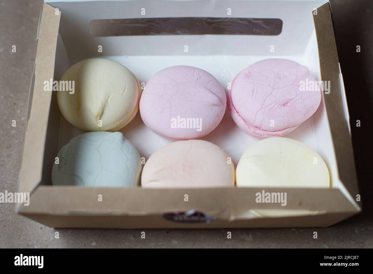 Six colorful handmade marshmallows in a cardboard box on the table ...