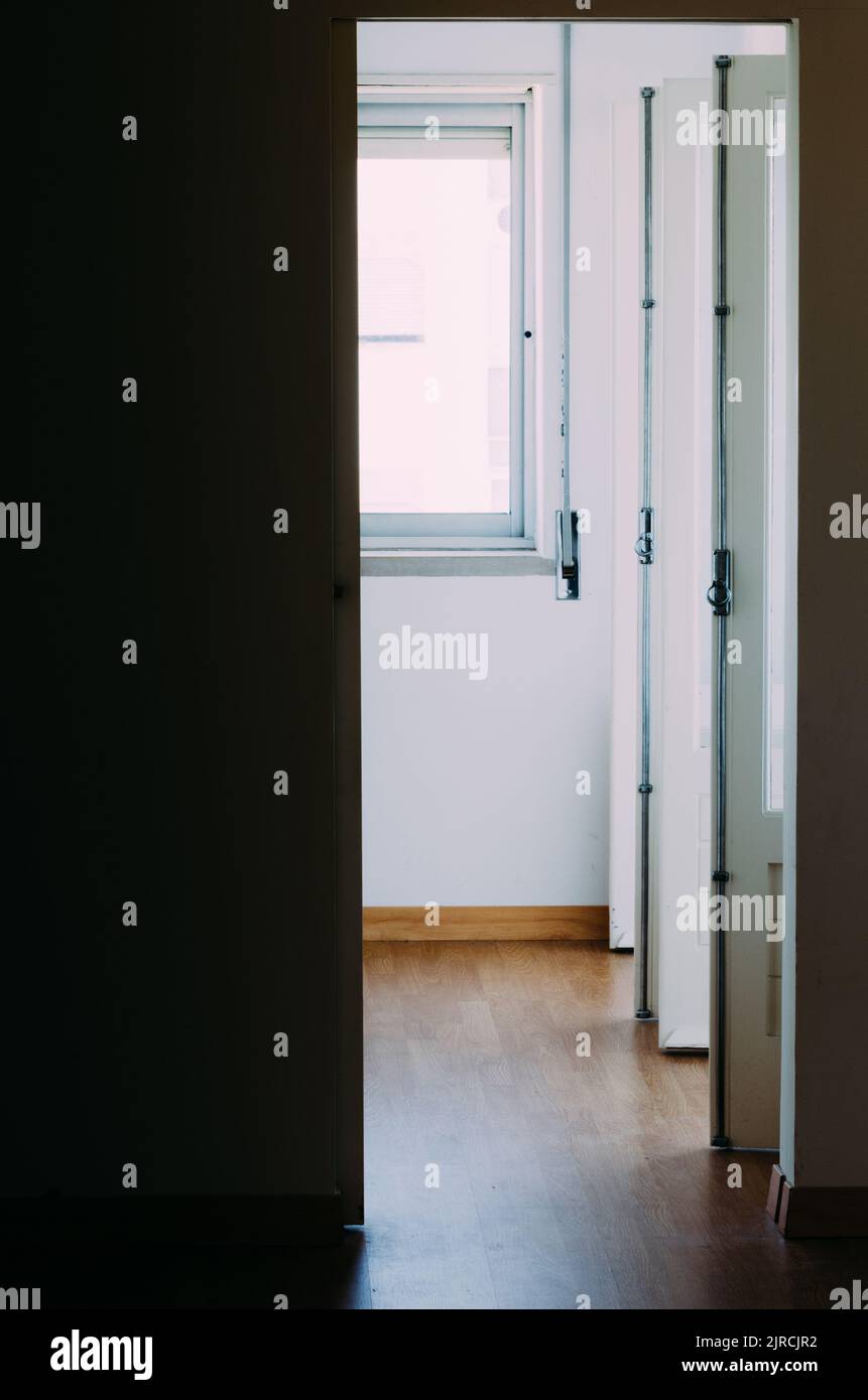A vertical shot of empty white room with rows of three open doors Stock ...