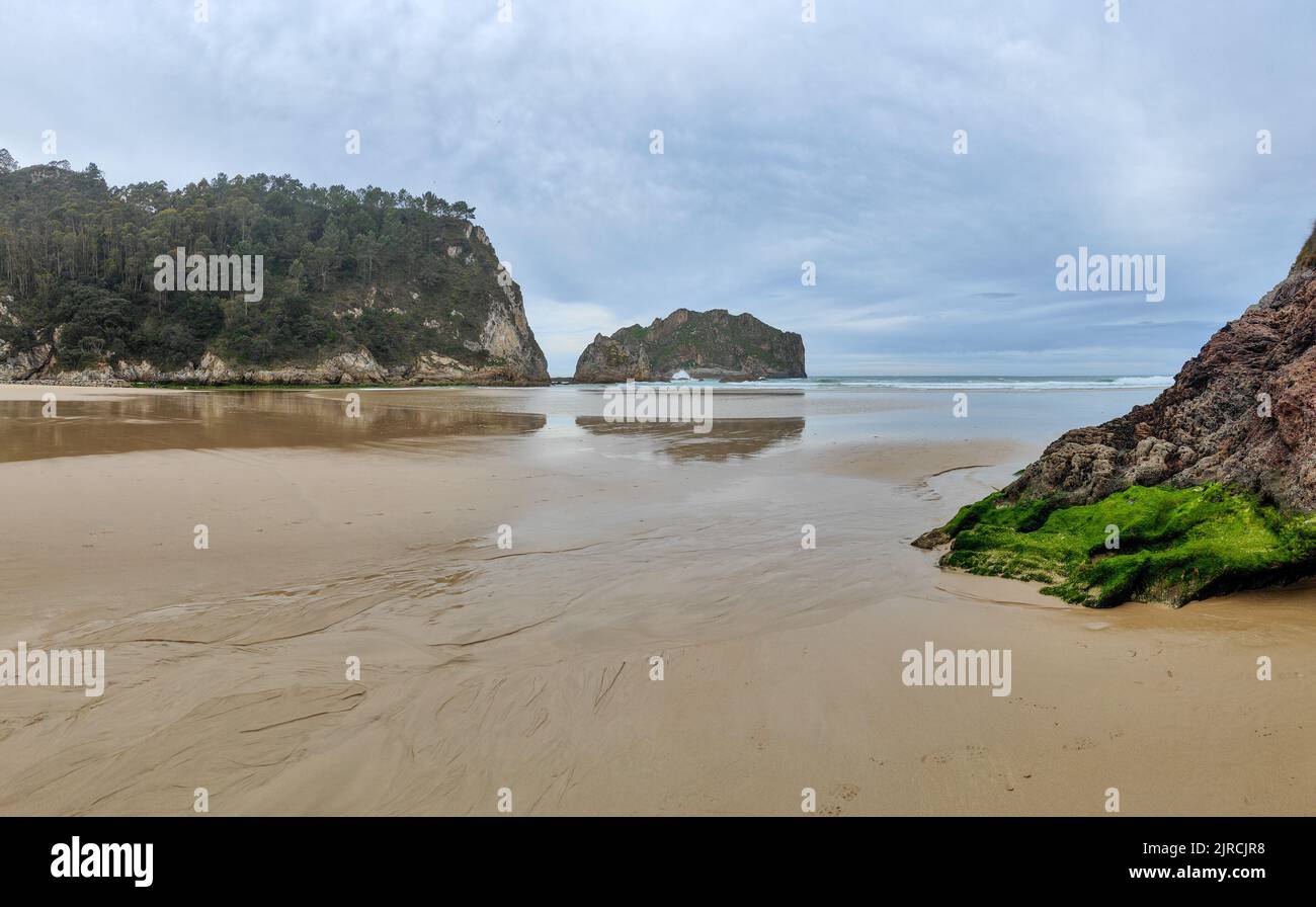 A landscape view of a beach surrounded by rocks Stock Photo - Alamy