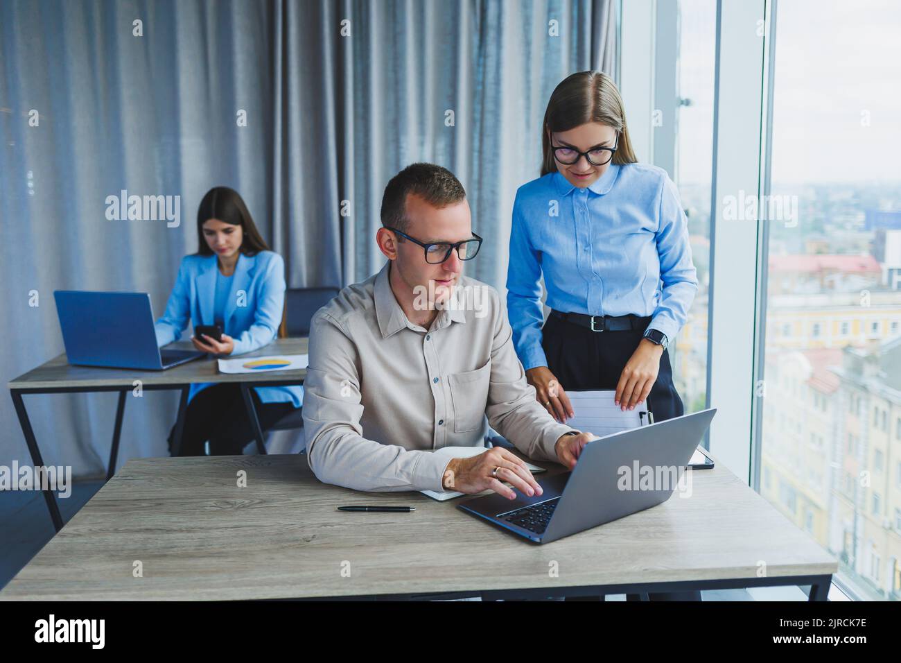 Two manager employees in a modern office, Europeans man and woman ...