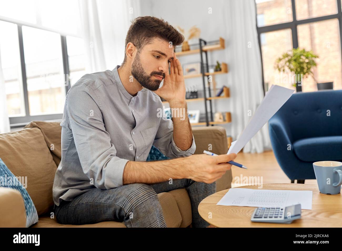 stressed man with bills at home Stock Photo - Alamy