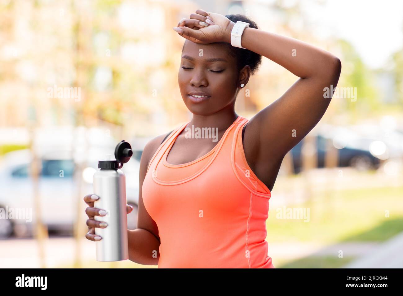 tired african american woman with bottle of water Stock Photo - Alamy