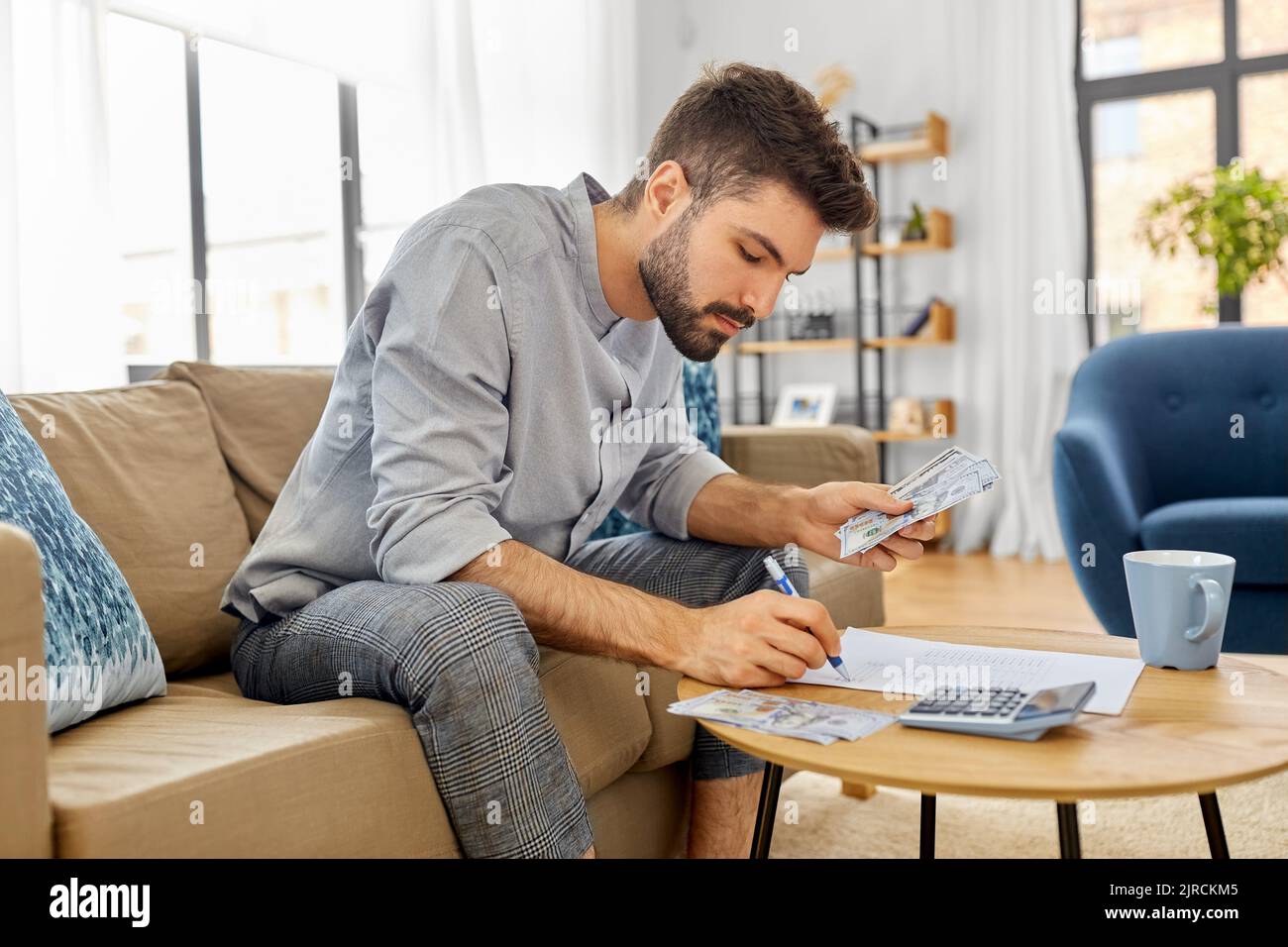 man with money and calculator filling papers Stock Photo - Alamy