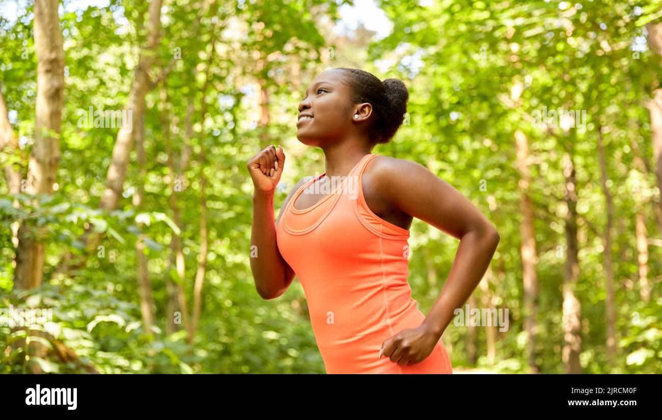 happy african american woman running in forest Stock Photo - Alamy
