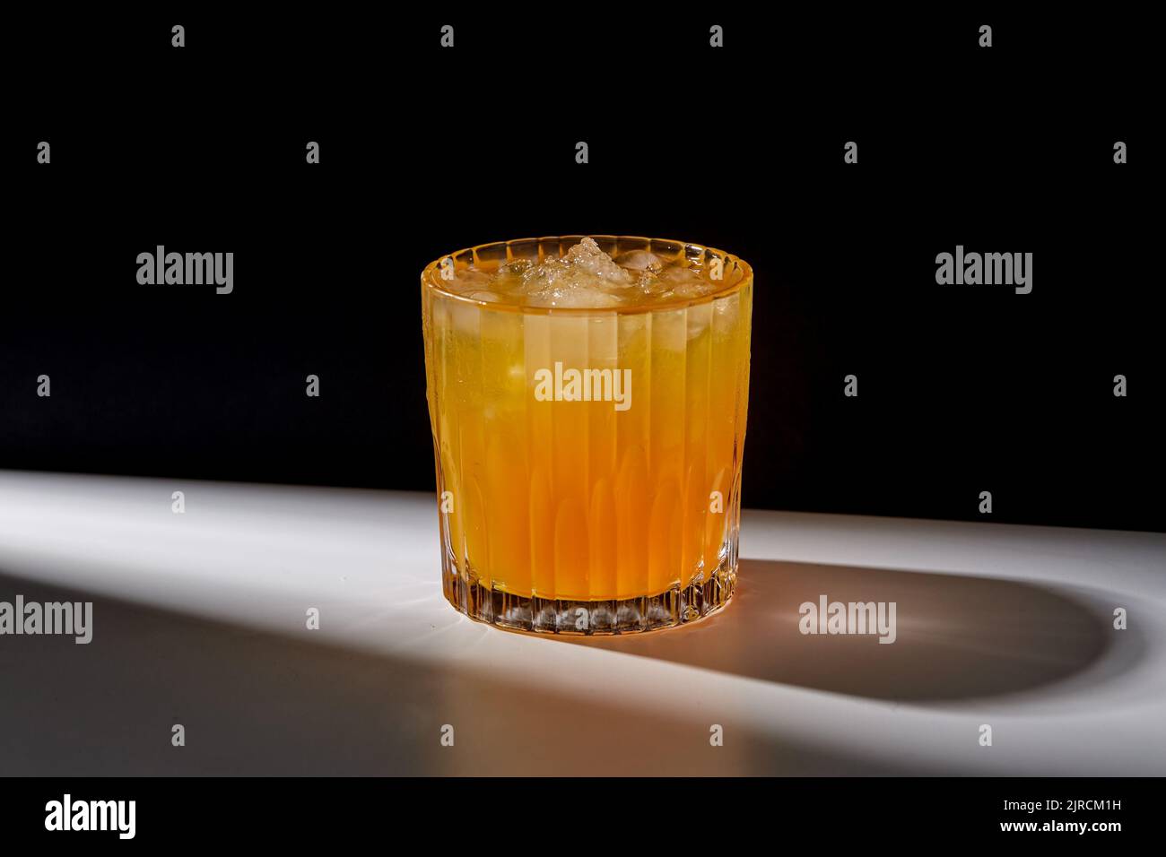 glass of orange juice with ice on table Stock Photo - Alamy