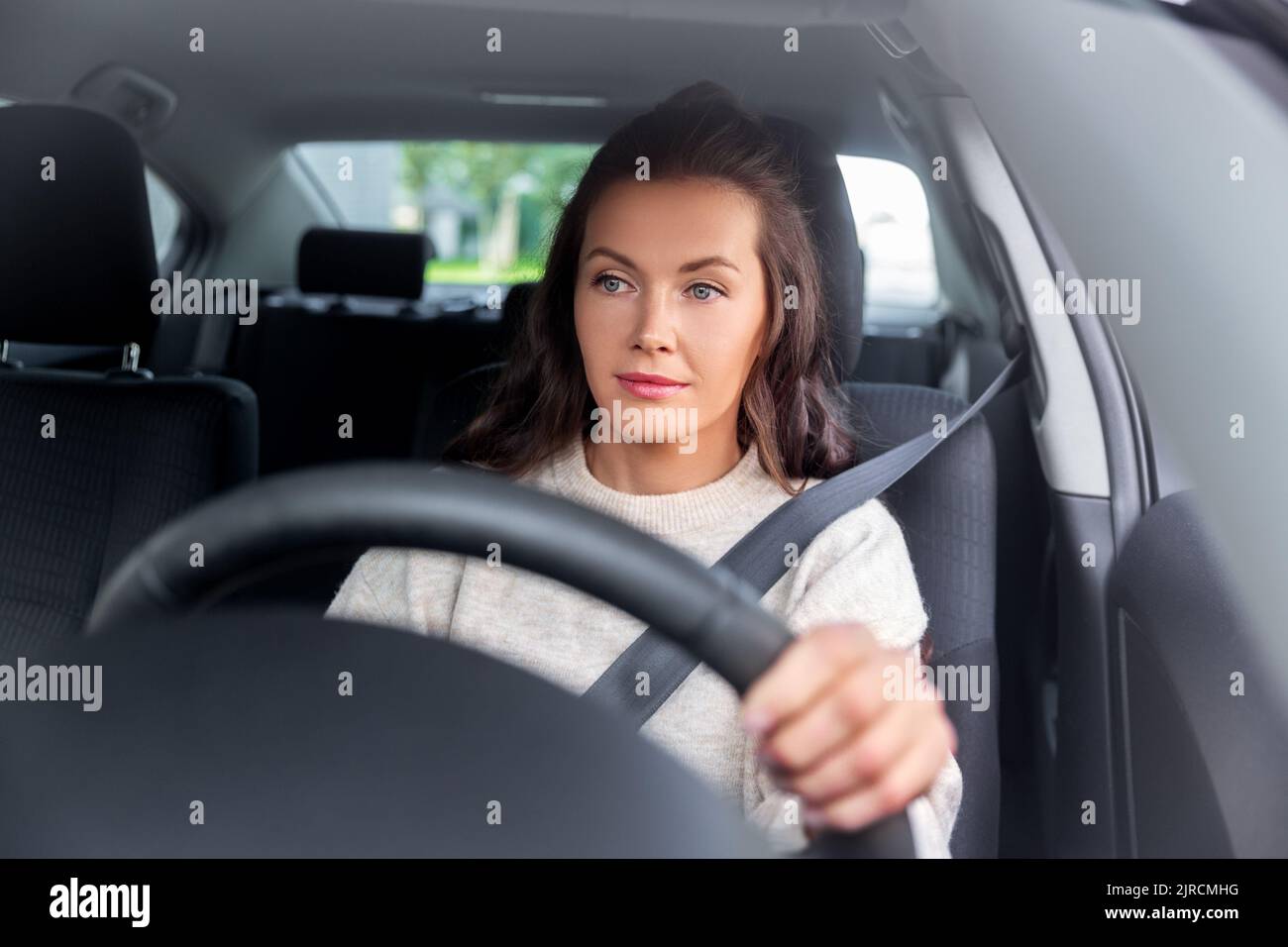 woman or female driver driving car in city Stock Photo - Alamy