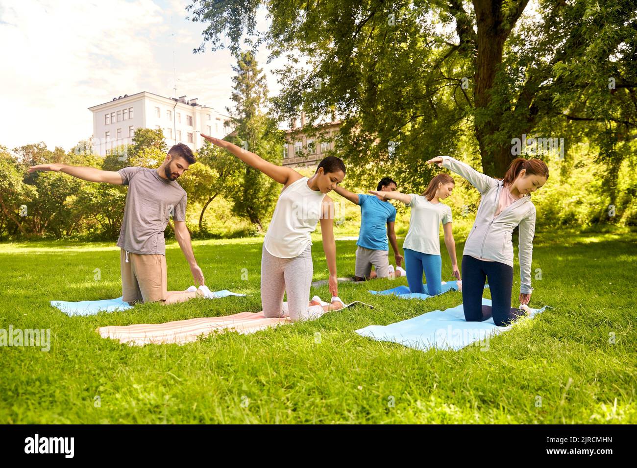 group of people doing yoga at summer park Stock Photo - Alamy
