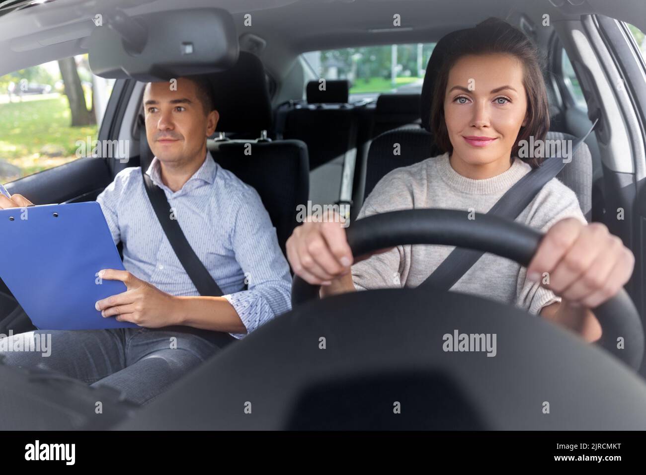 car driving school instructor and young driver Stock Photo - Alamy