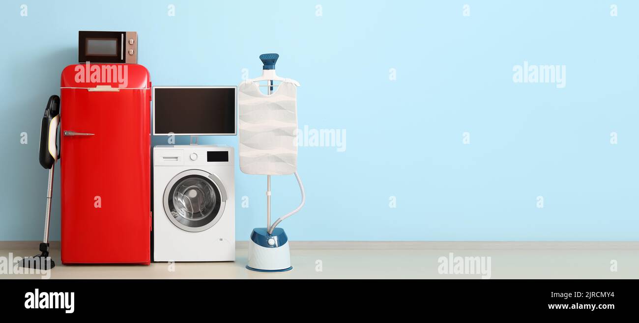 Stylish household appliances on light blue background with space for ...