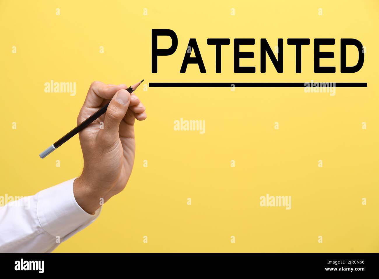 Male hand with pencil and word PATENTED on yellow background Stock ...