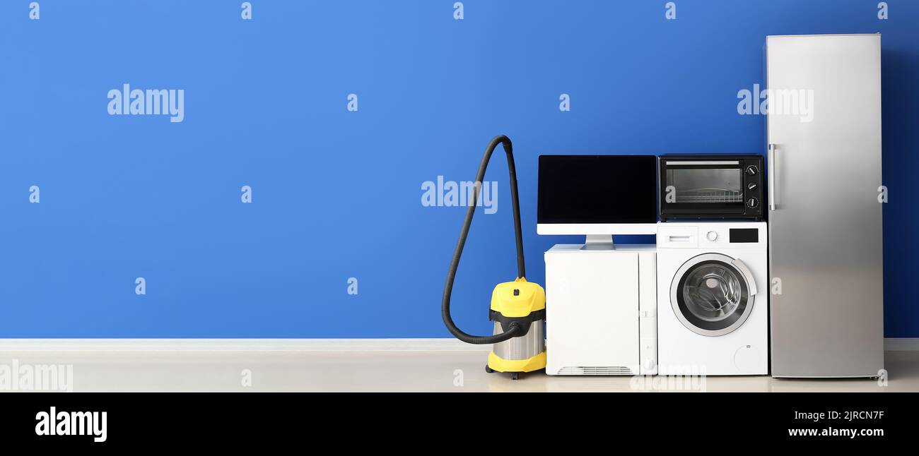 Different household appliances on blue background with space for text ...