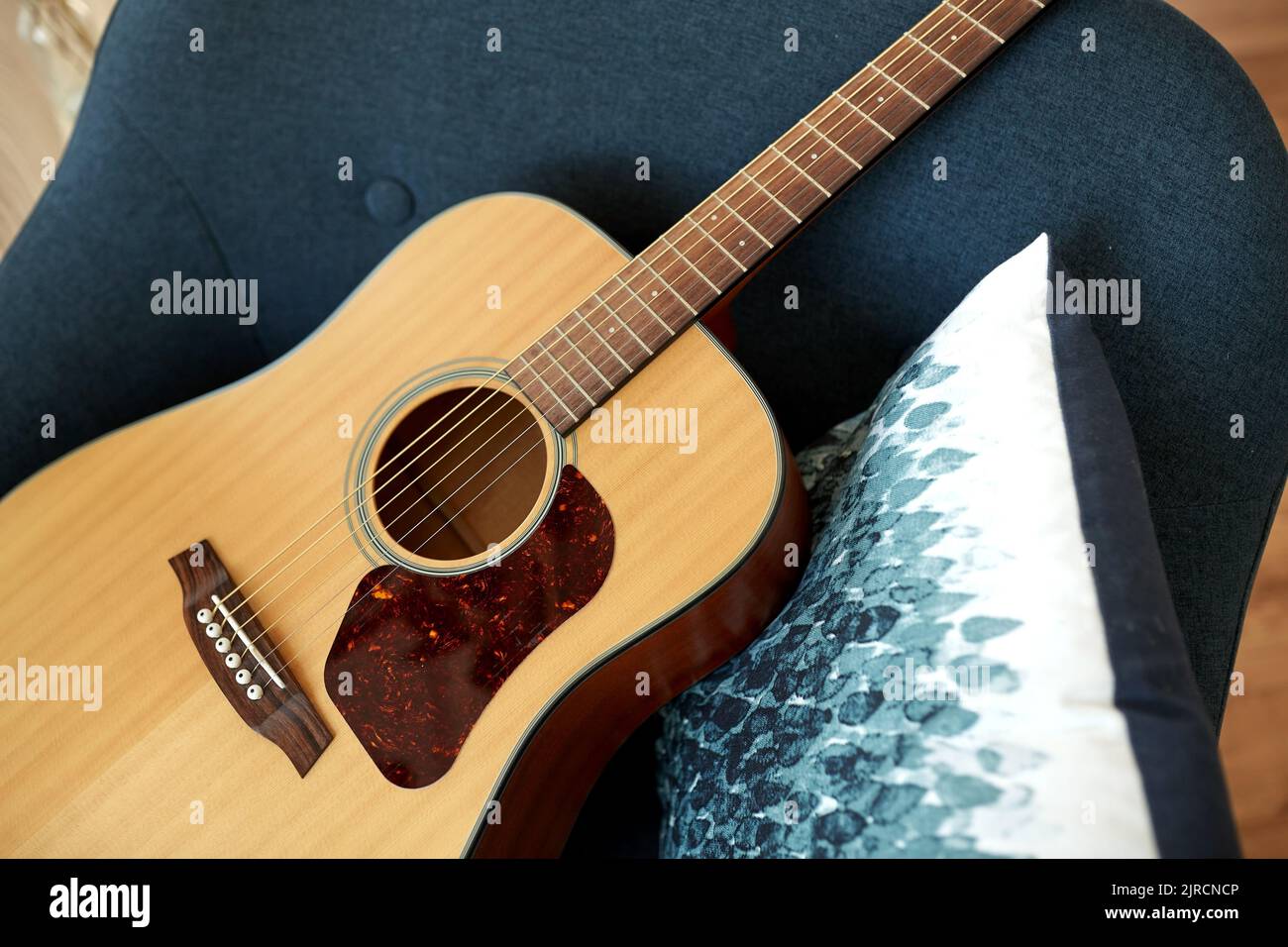 close up of acoustic guitar on armchair Stock Photo - Alamy