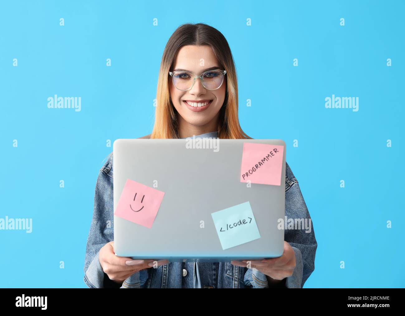 Transgender programmer with laptop on blue background Stock Photo - Alamy