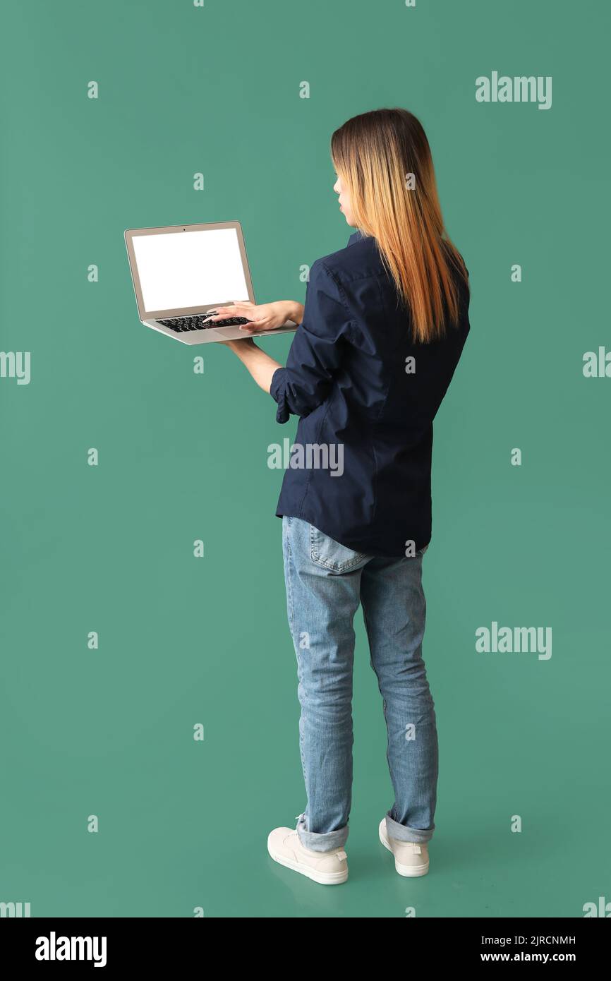 Transgender programmer with laptop on green background Stock Photo - Alamy