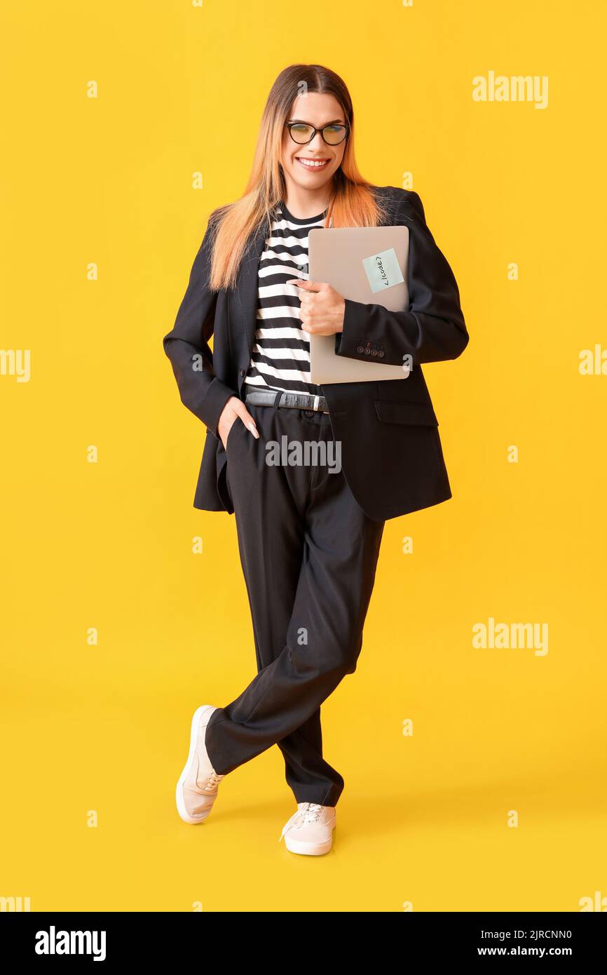 Transgender programmer with laptop on yellow background Stock Photo - Alamy