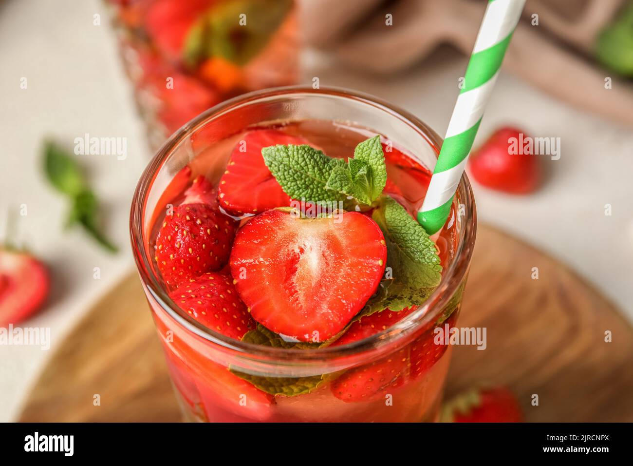 Glass of strawberry lemonade with straw on white background, closeup ...