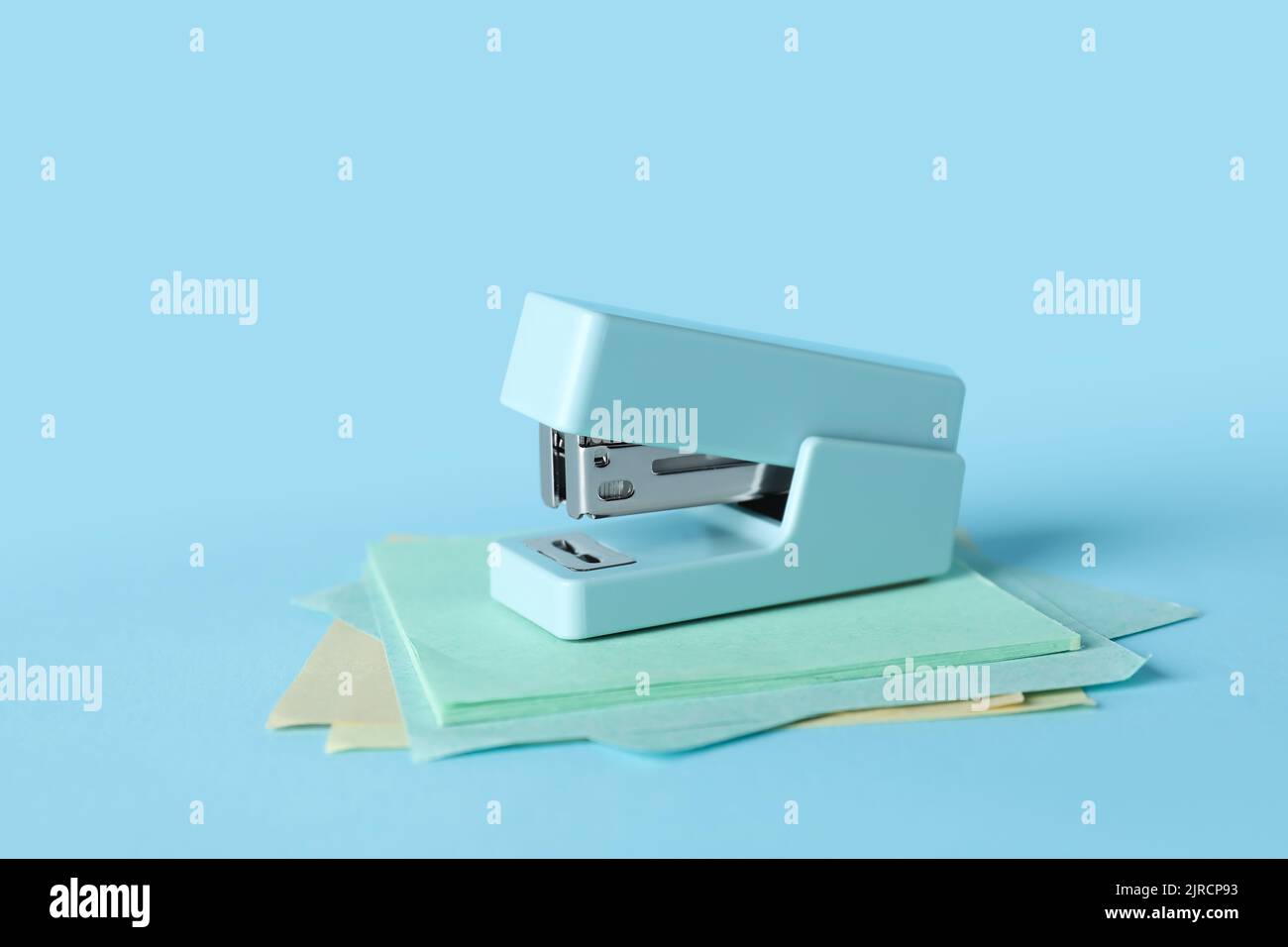Stapler with sticky notes on blue background Stock Photo - Alamy
