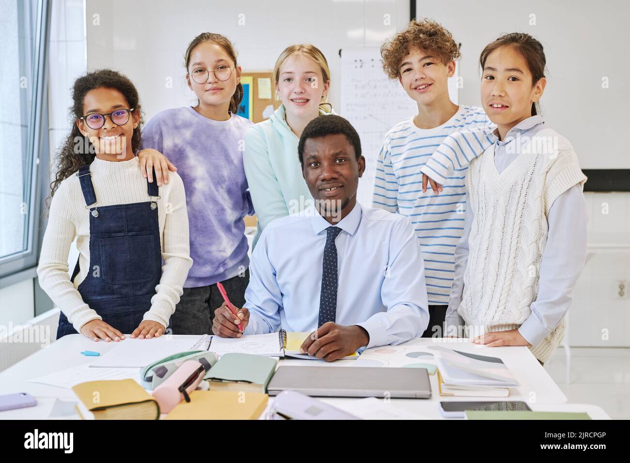 Front view portrait of young black teacher with diverse group of ...