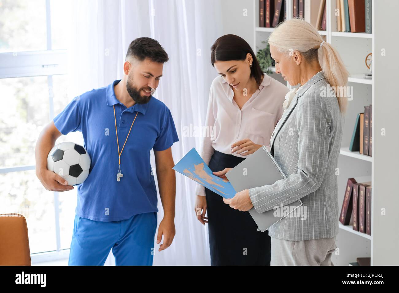 Teachers with world map in school office Stock Photo - Alamy