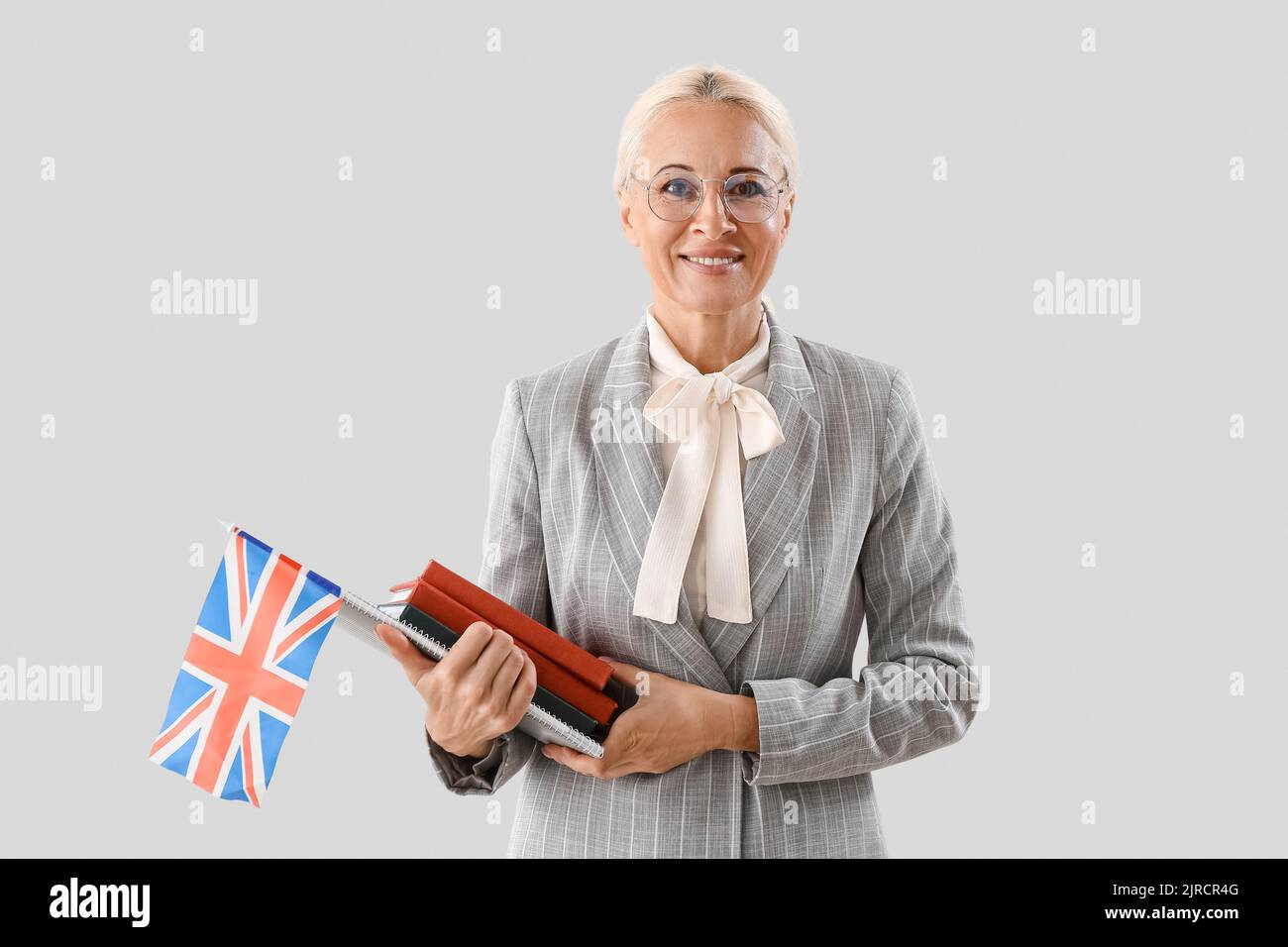 Mature English teacher with UK flag and books on light background Stock ...