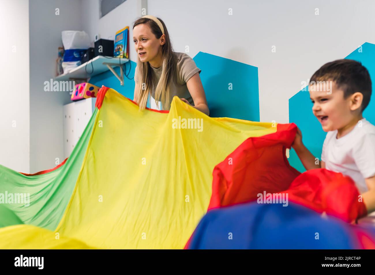 Happy toddler and his teacher engaged in an active sensory play with ...