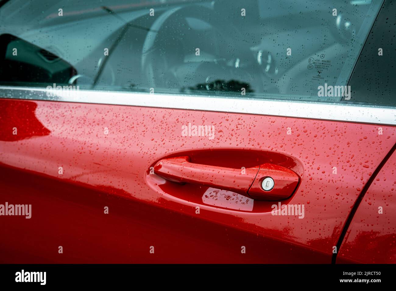 A closeup shot of door's handle of a red Mercedes GLA 200 details on a ...