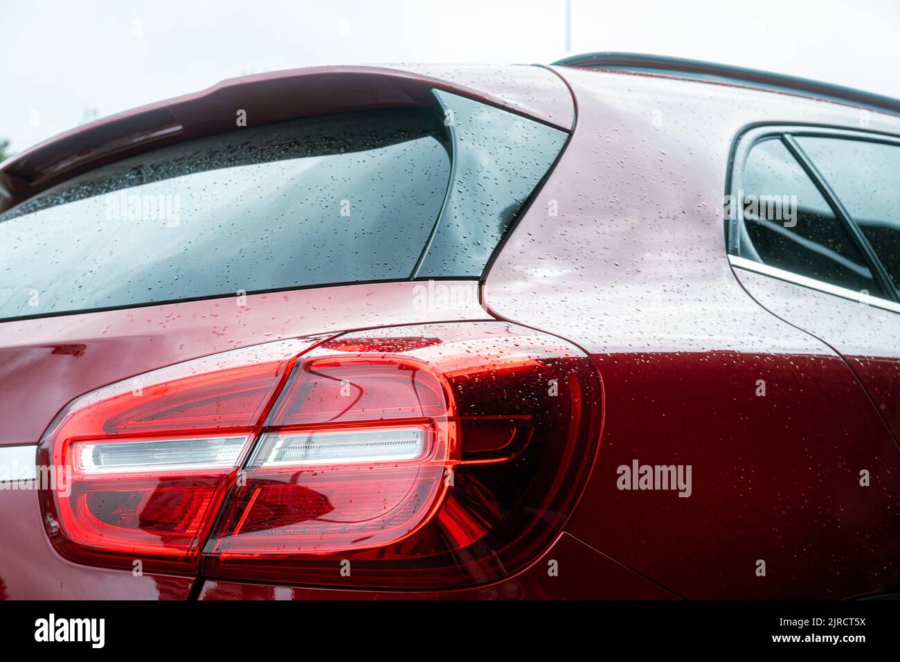 The back highlight of red Mercedes GLA 200 on a rainy day Stock Photo ...